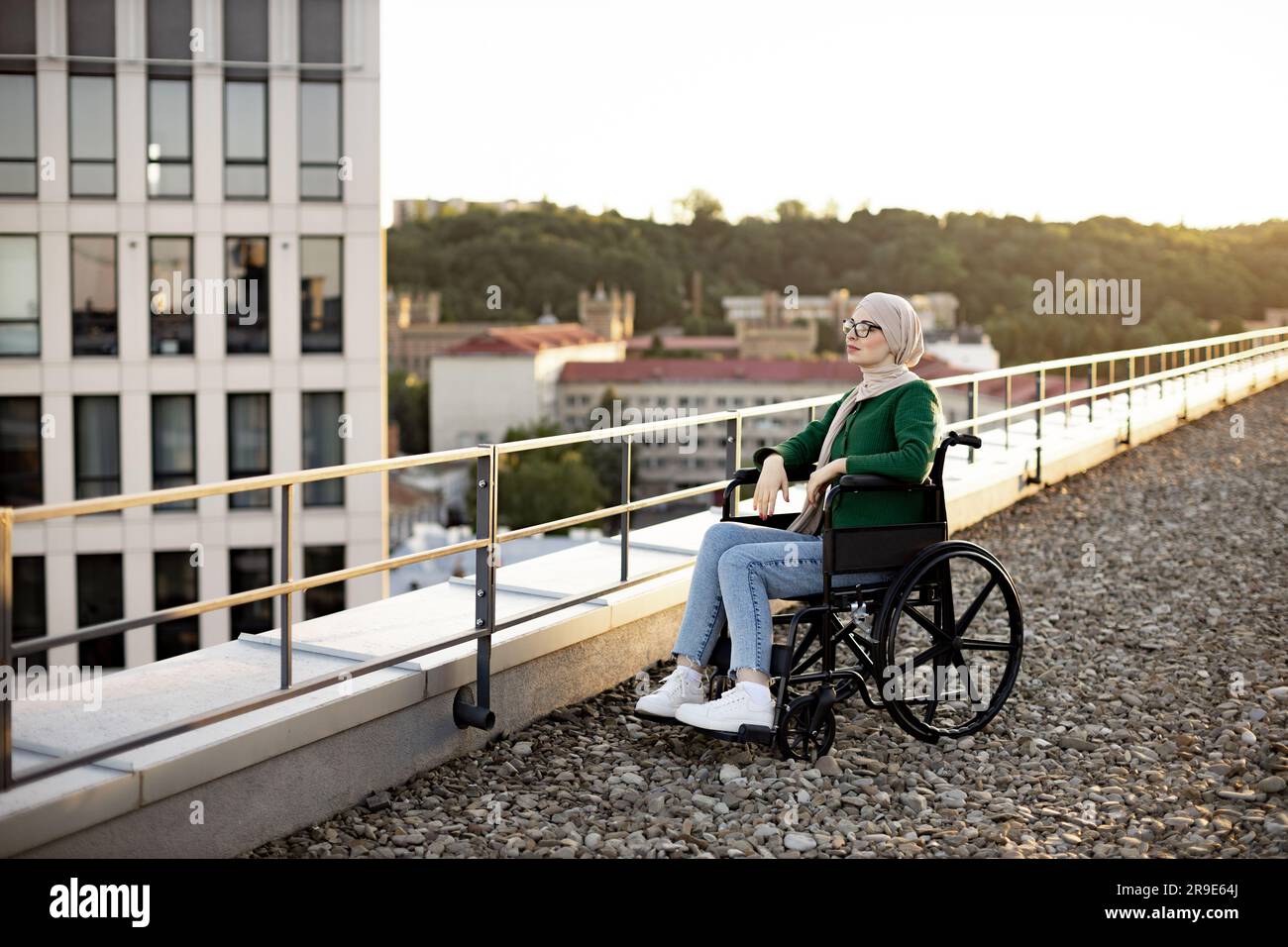 Pretty bespectacled woman with mobility issues daydreaming with hands ...