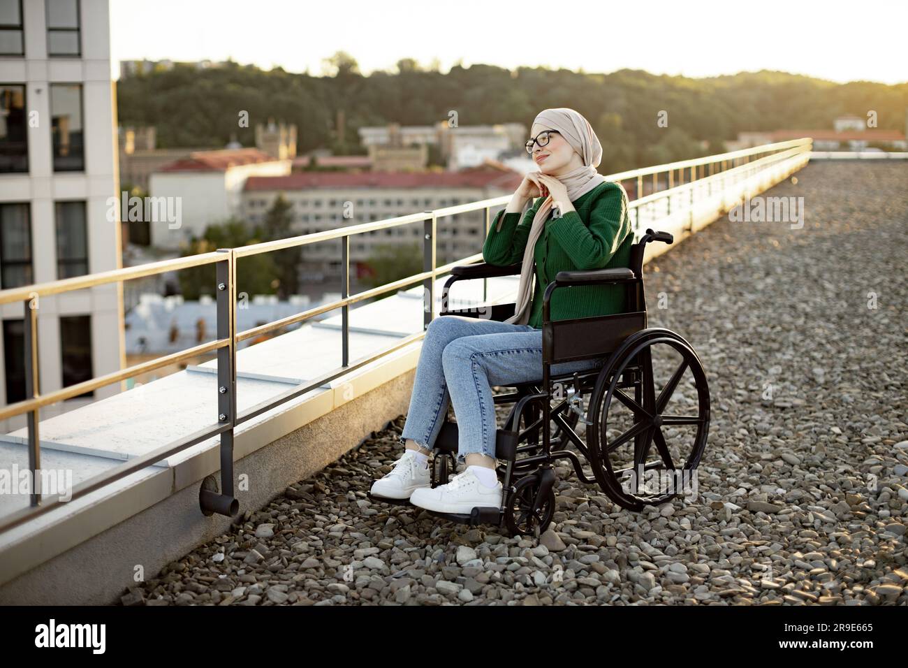 Pretty bespectacled woman with mobility issues daydreaming with hands ...