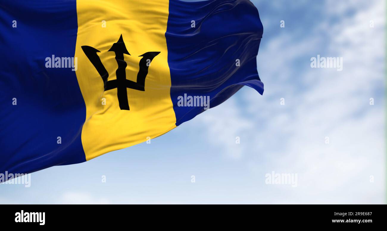 Barbados national flag waving on a clear day. Blue and yellow flag with ...