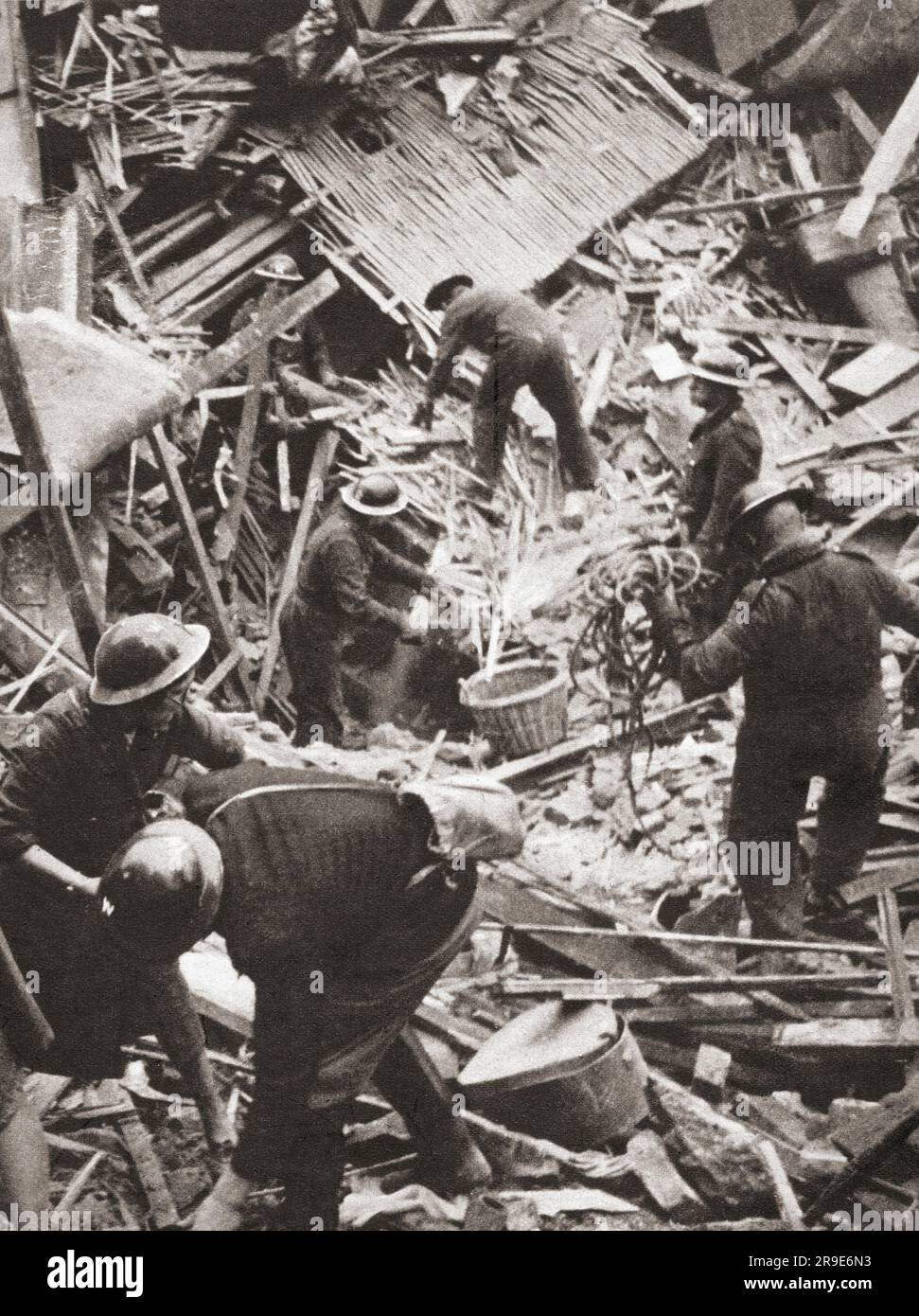 Civilian volunteers search through the rubble of a bombed building ...