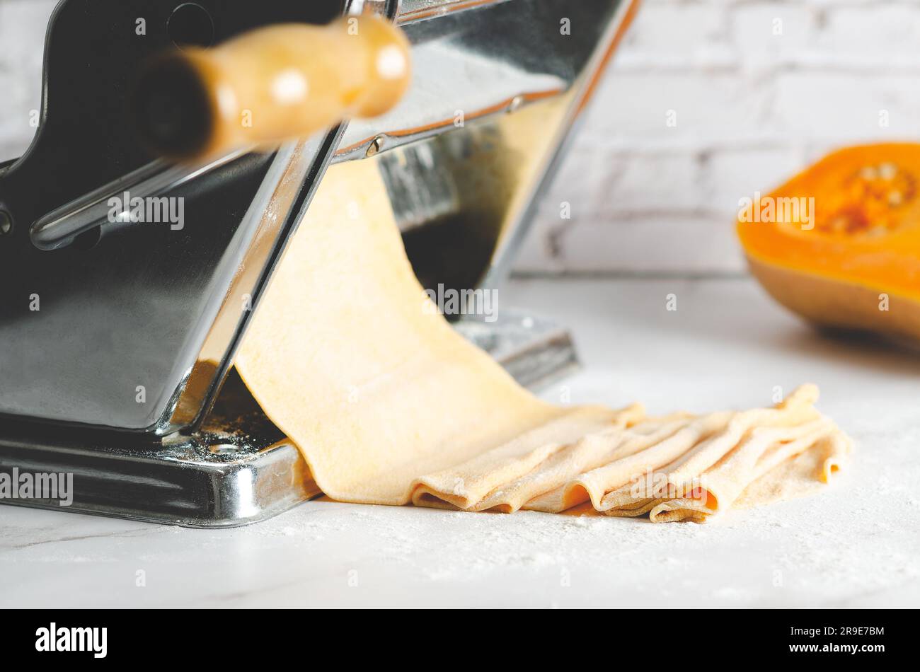 Butternut squash dough in a pasta maker machine, and a piece of ...