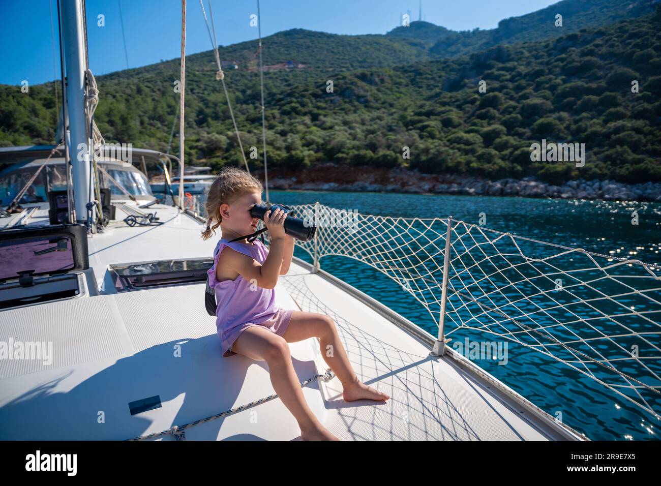 Little girl on a yacht looking through binoculars in the sea Stock ...