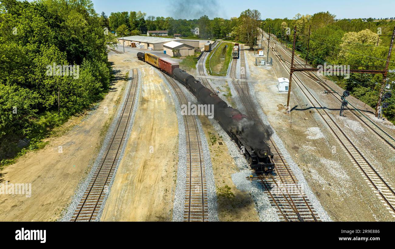 An Aerial View of a Steam Locomotive Moving Freight Cars Around in a ...