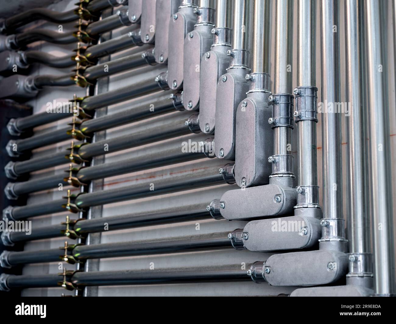 Wiring electric steel pipeline on concrete wall background. Steel tube ...