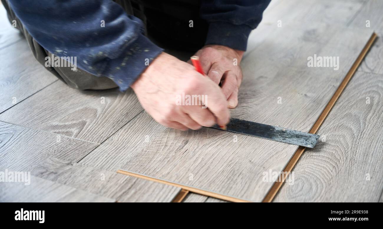 Close up of man hands using metal ruler and pencil while drawing line ...