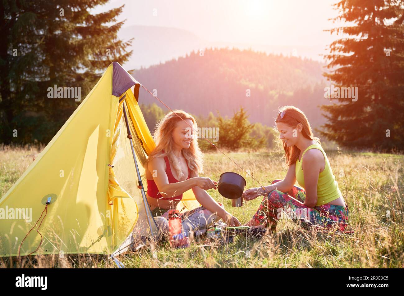 Two women tourists camping outdoors. Friends traveling, hiking outdoors ...