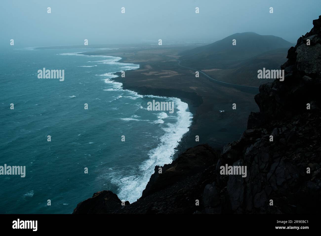 Landscape image with a dramatic view of a black sand beach and the ...