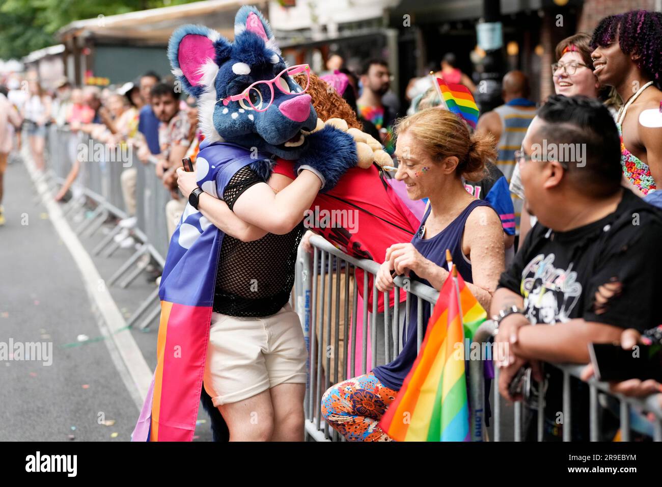 A participant dressed in a furry costume hugs a spectator in the NYC ...