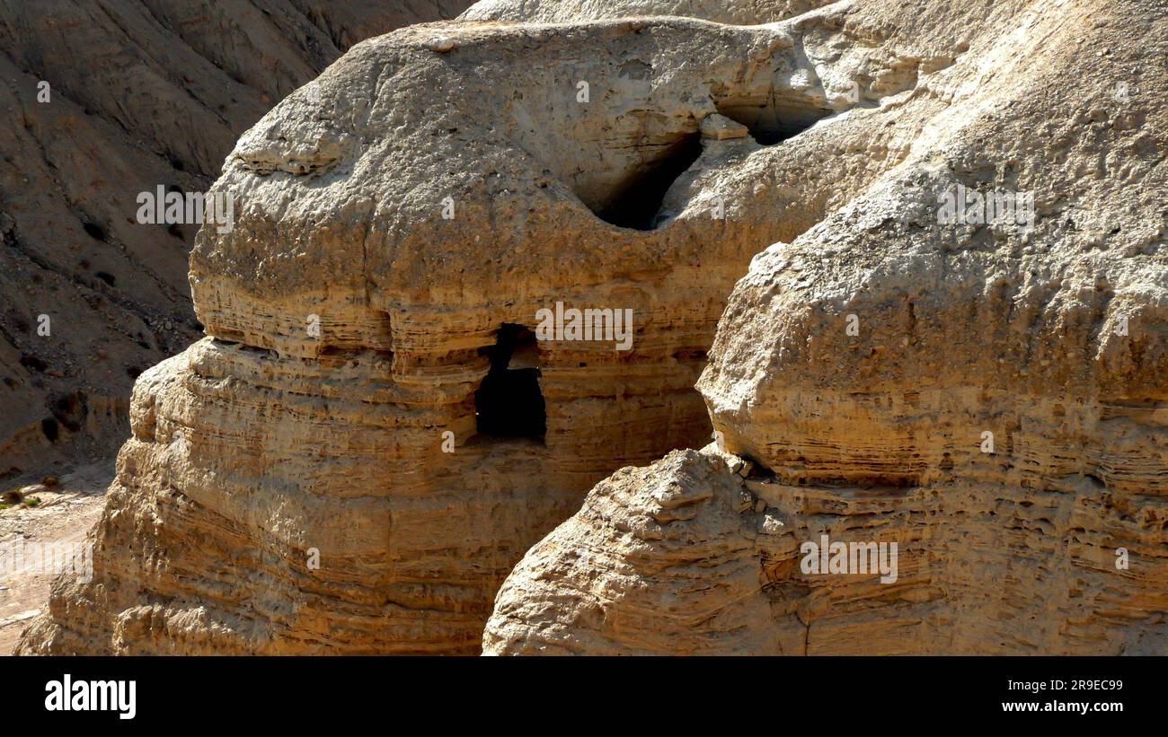 A picturesque cave opening in an arid desert landscape, featuring a ...
