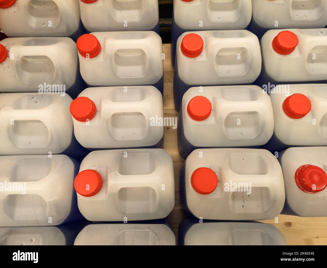 A selection of plastic containers sorted in a row with red caps Stock ...