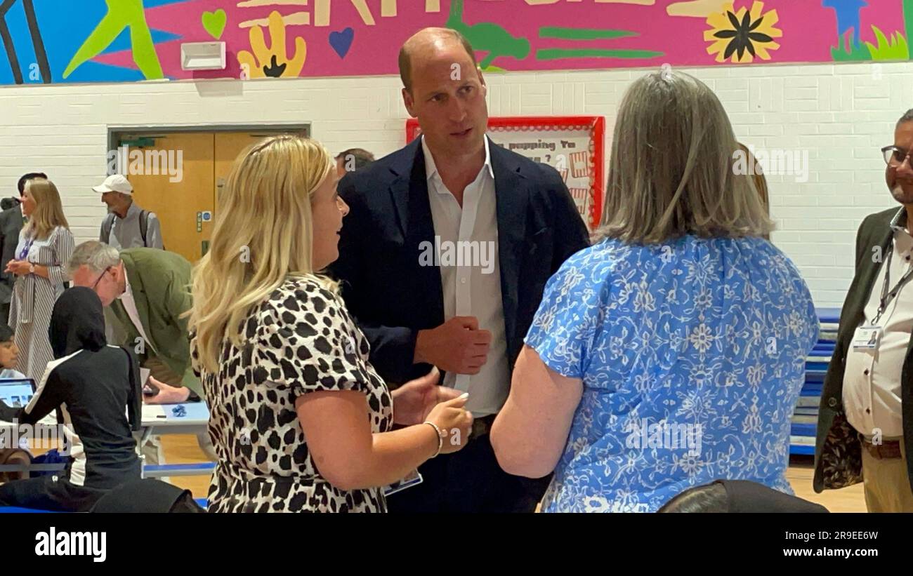 The Prince of Wales speaks with members of staff during a visit to ...