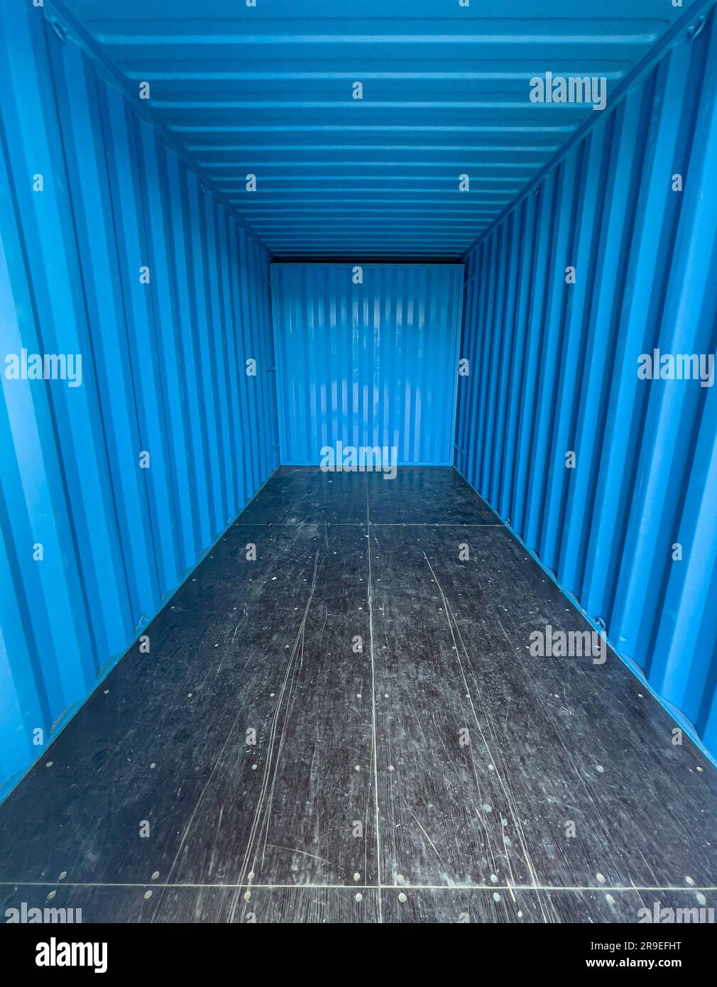 Blue interior of an empty metal shipping container. Shot from the ...