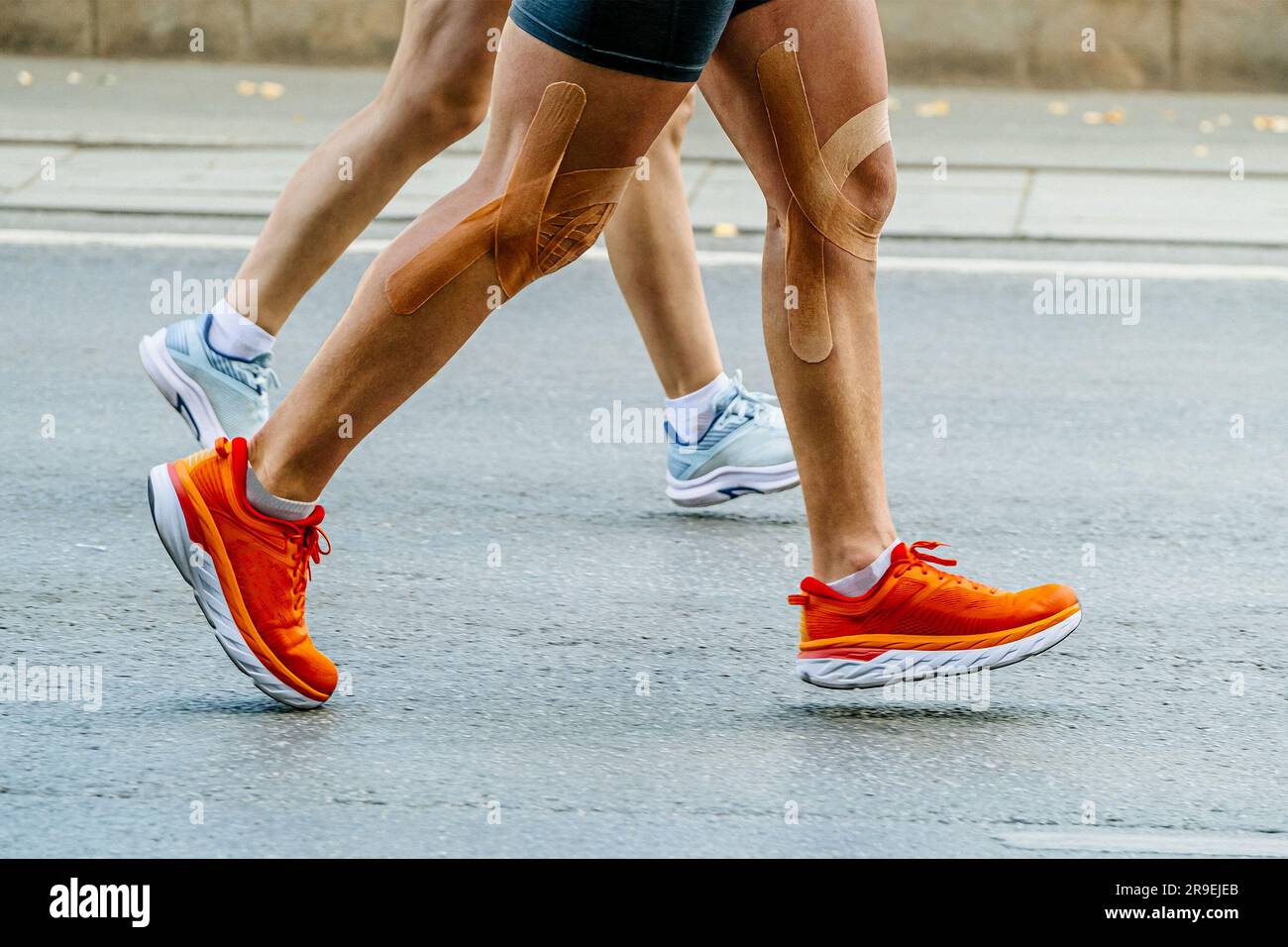 close-up legs couple runners man and woman running marathon race ...