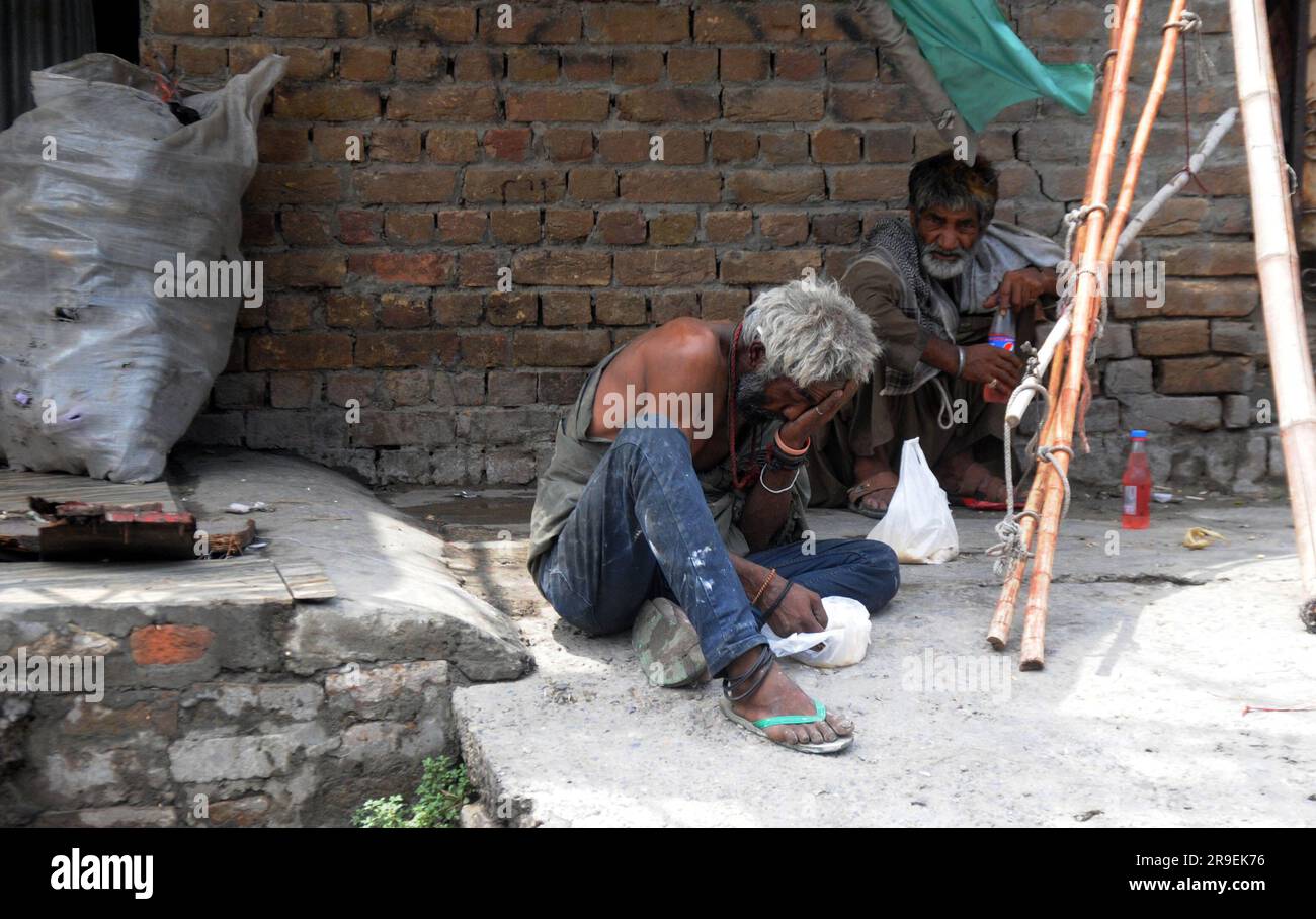 A Pakistani drug addict smokes heroin on the side of the road in ...