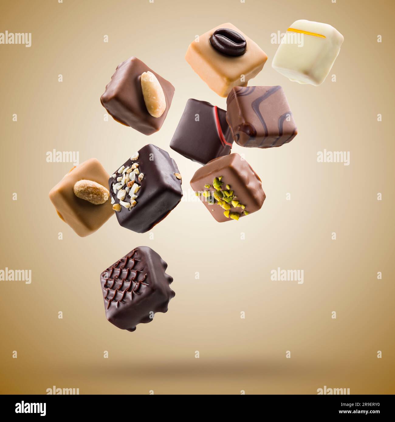 Assorted chocolate pralines floating on brown background Stock Photo ...
