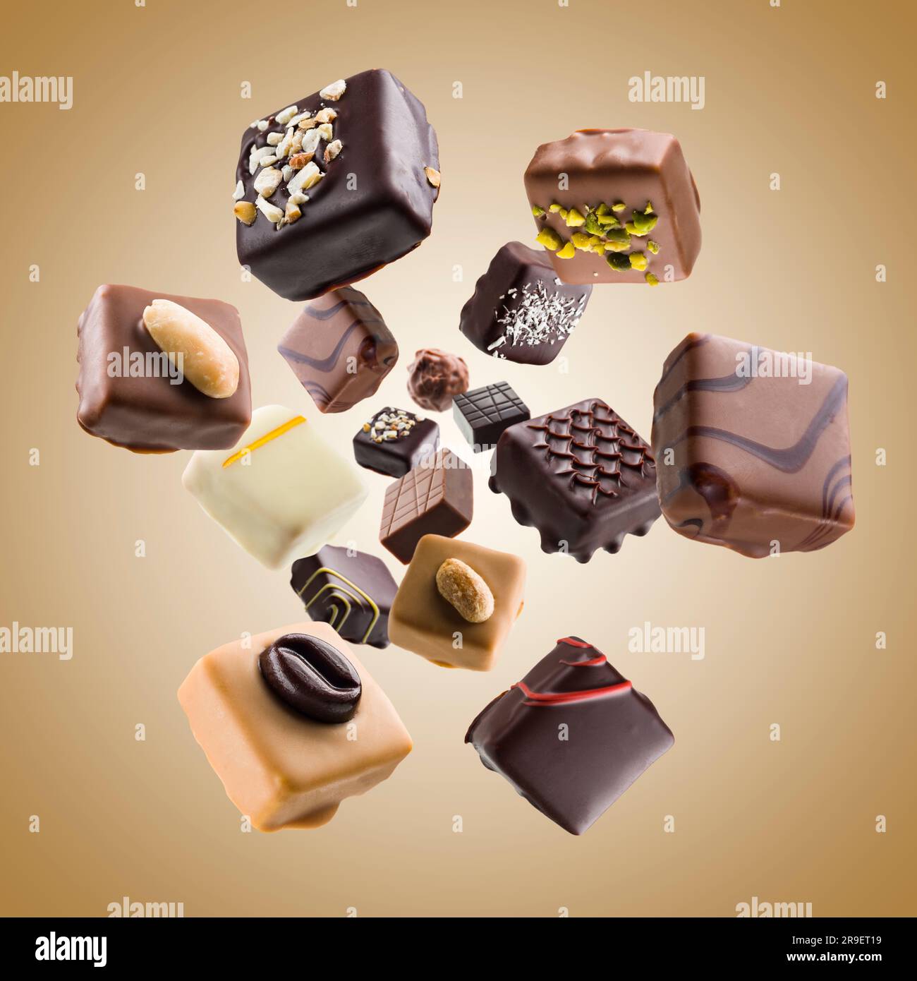 Assorted chocolate pralines falling on colored background Stock Photo ...