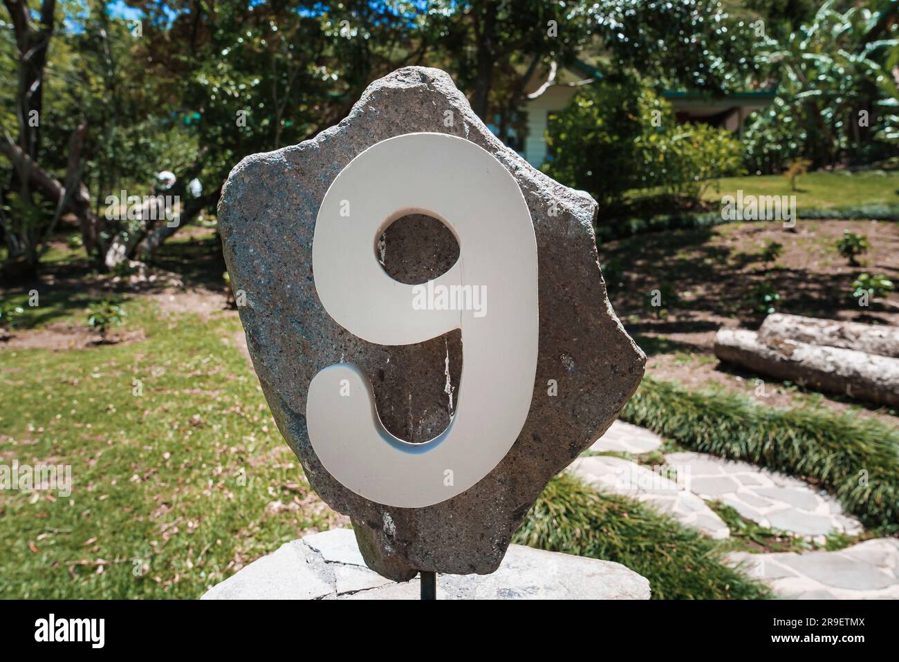 House number 9 installed on a big rock in the garden of residence Stock ...