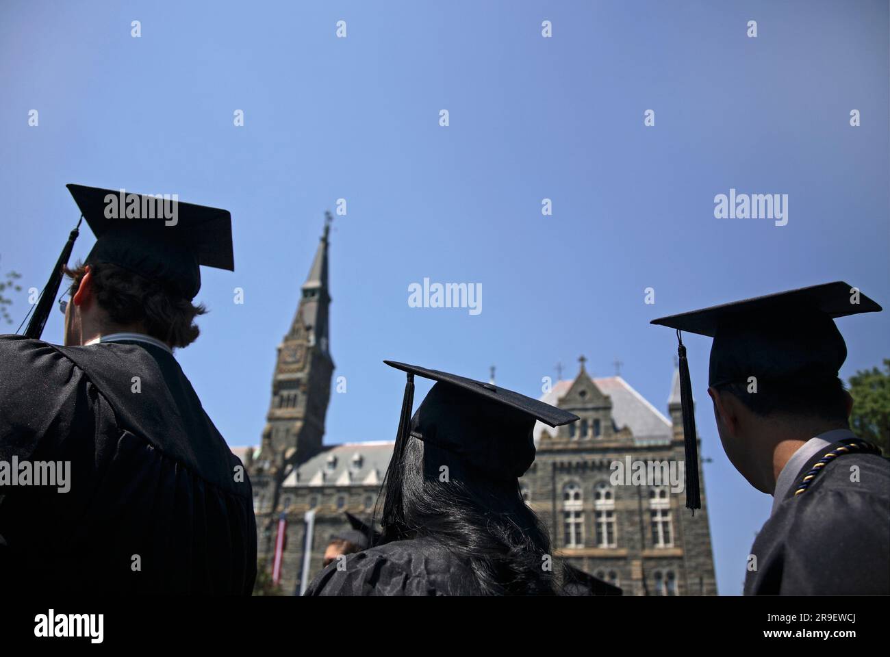 Students dressed with the traditional cap and gown participating in the ...