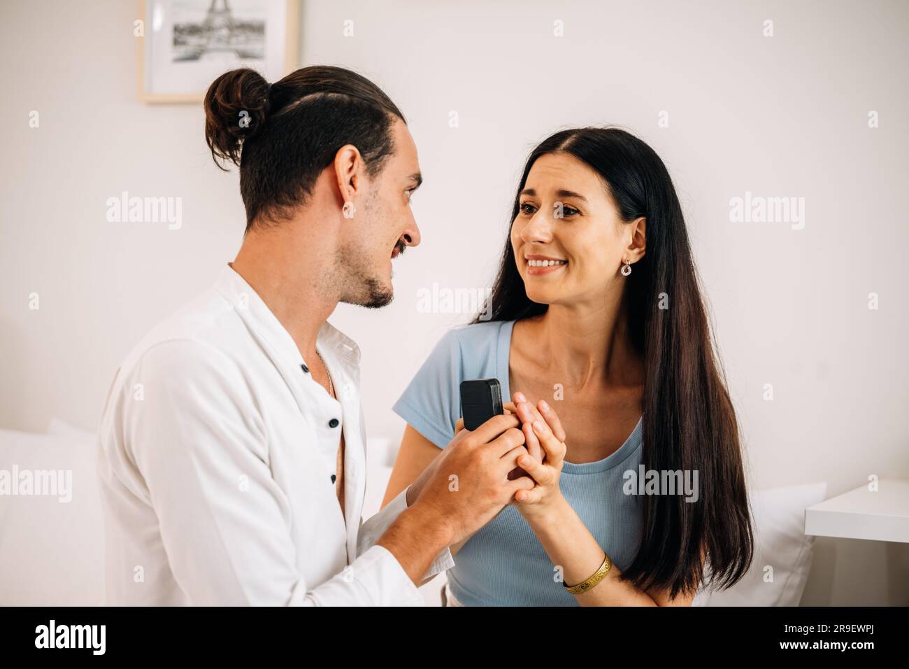 Romantic couple making love promise with ring to each other at home ...