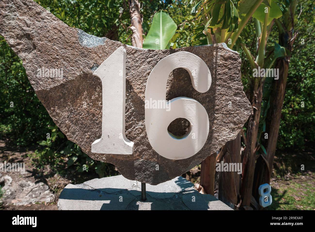 House number 16 installed on a big rock in the garden of residence Stock Photo - Alamy