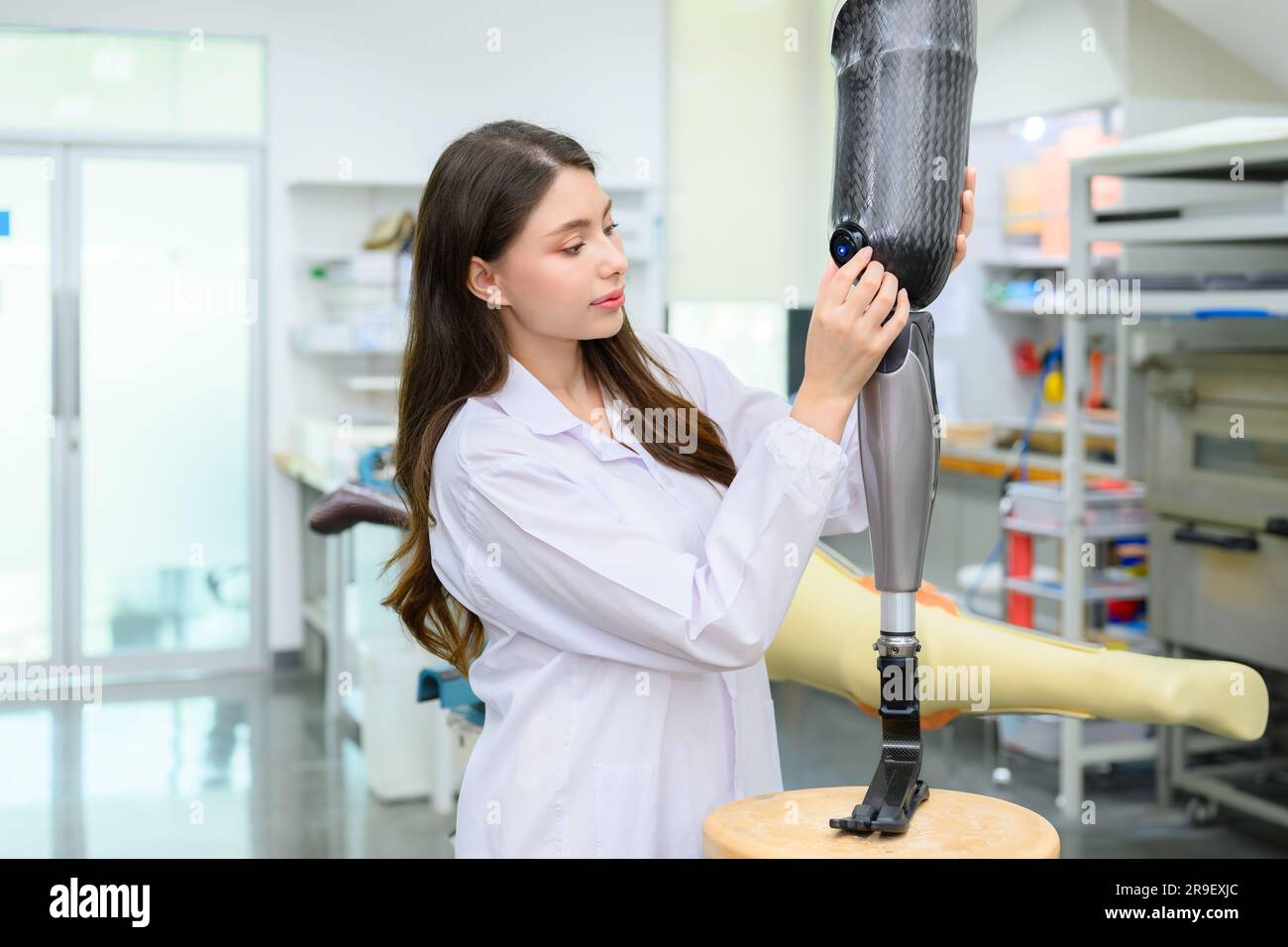 Technician holding prosthetic limb checking and working in laboratory ...
