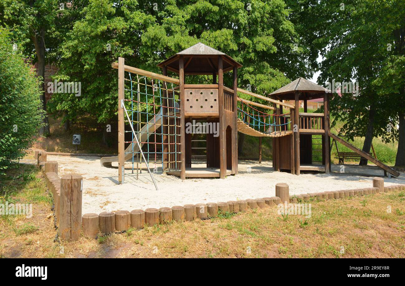 Kids playground construction of wooden huts and climbing net bridge and ...