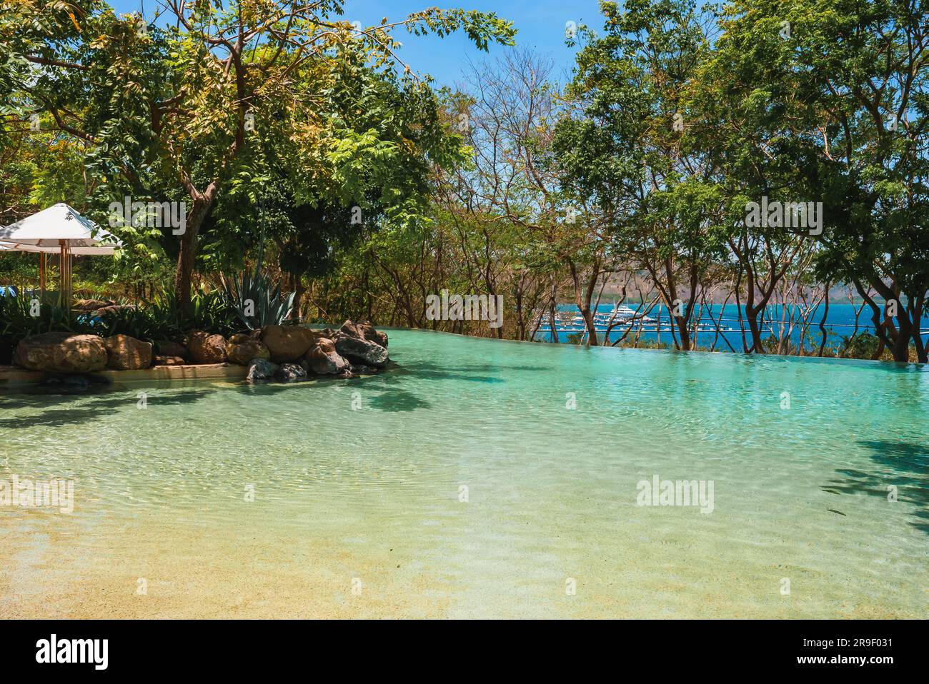 Resort hotel swimming pool with seascape in the background Stock Photo ...