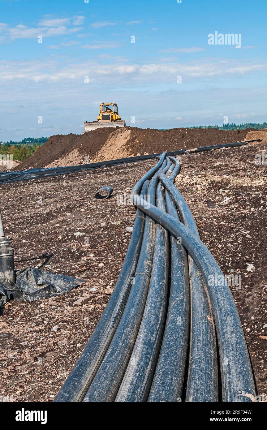 A soil compactor bulldozer tractor moves (contours) dirt around in an ...