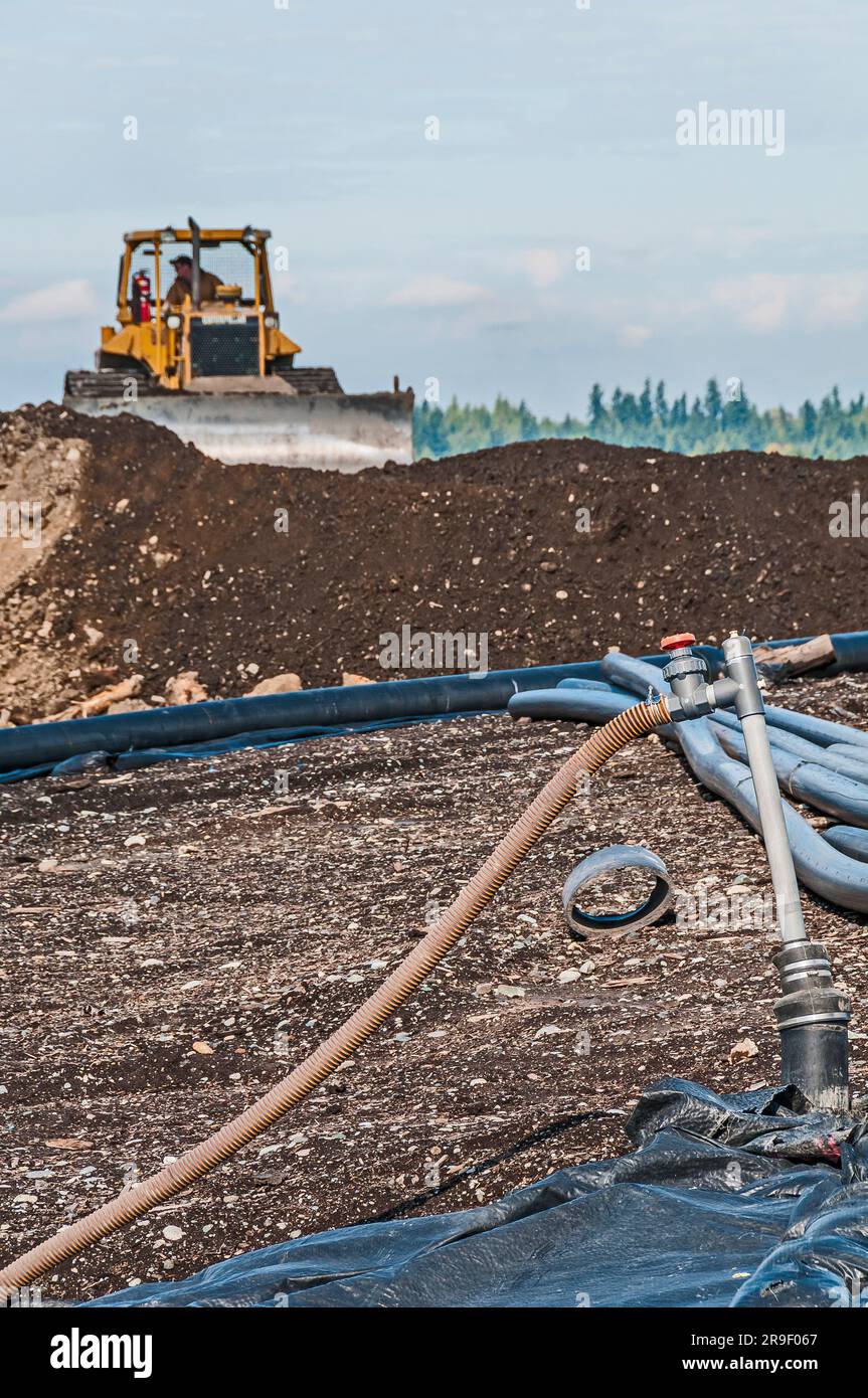 A soil compactor bulldozer tractor moves (contours) dirt around in an ...