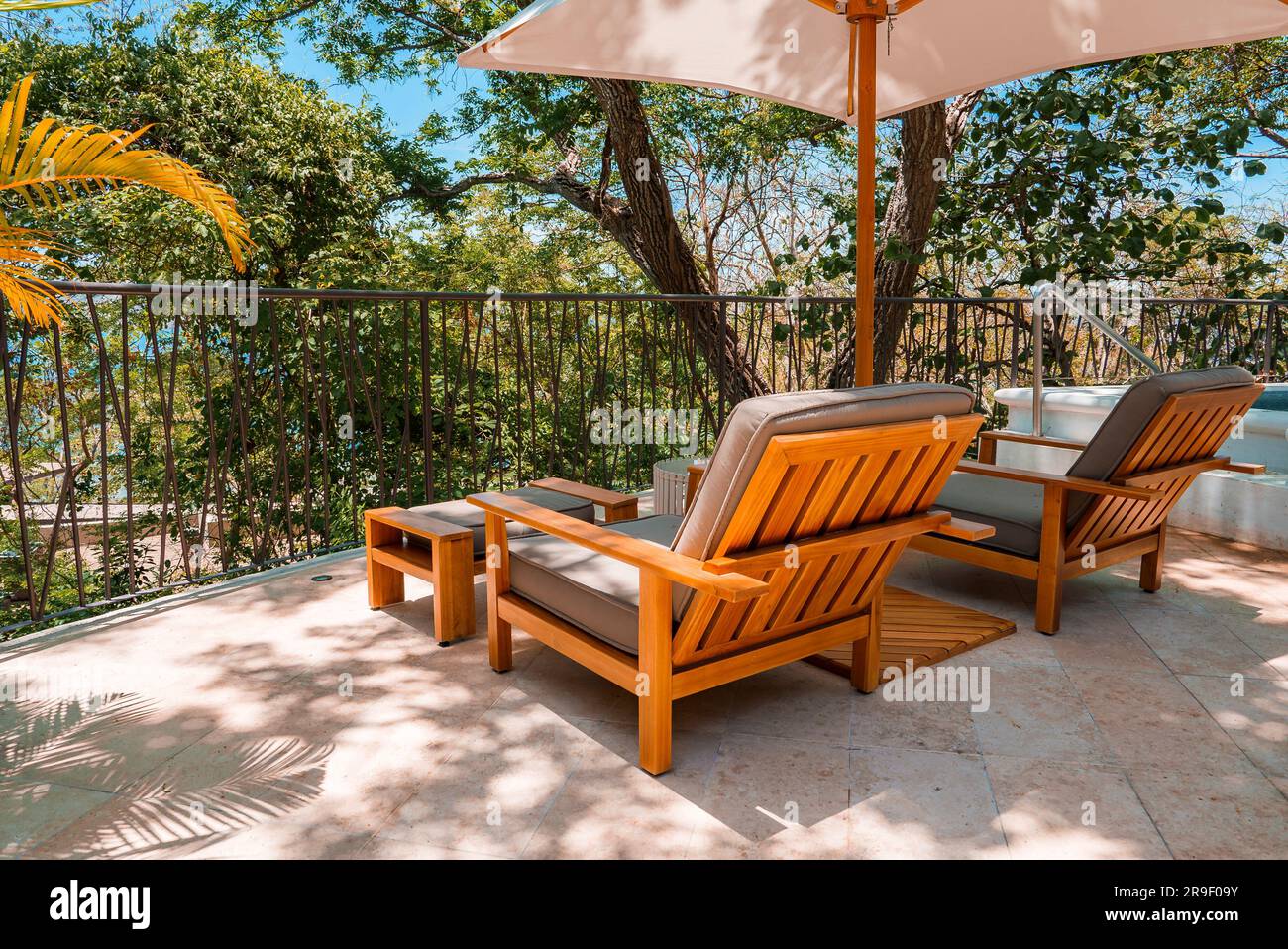 Pair of deckchairs with canopy next to swimming pool at luxury resort ...