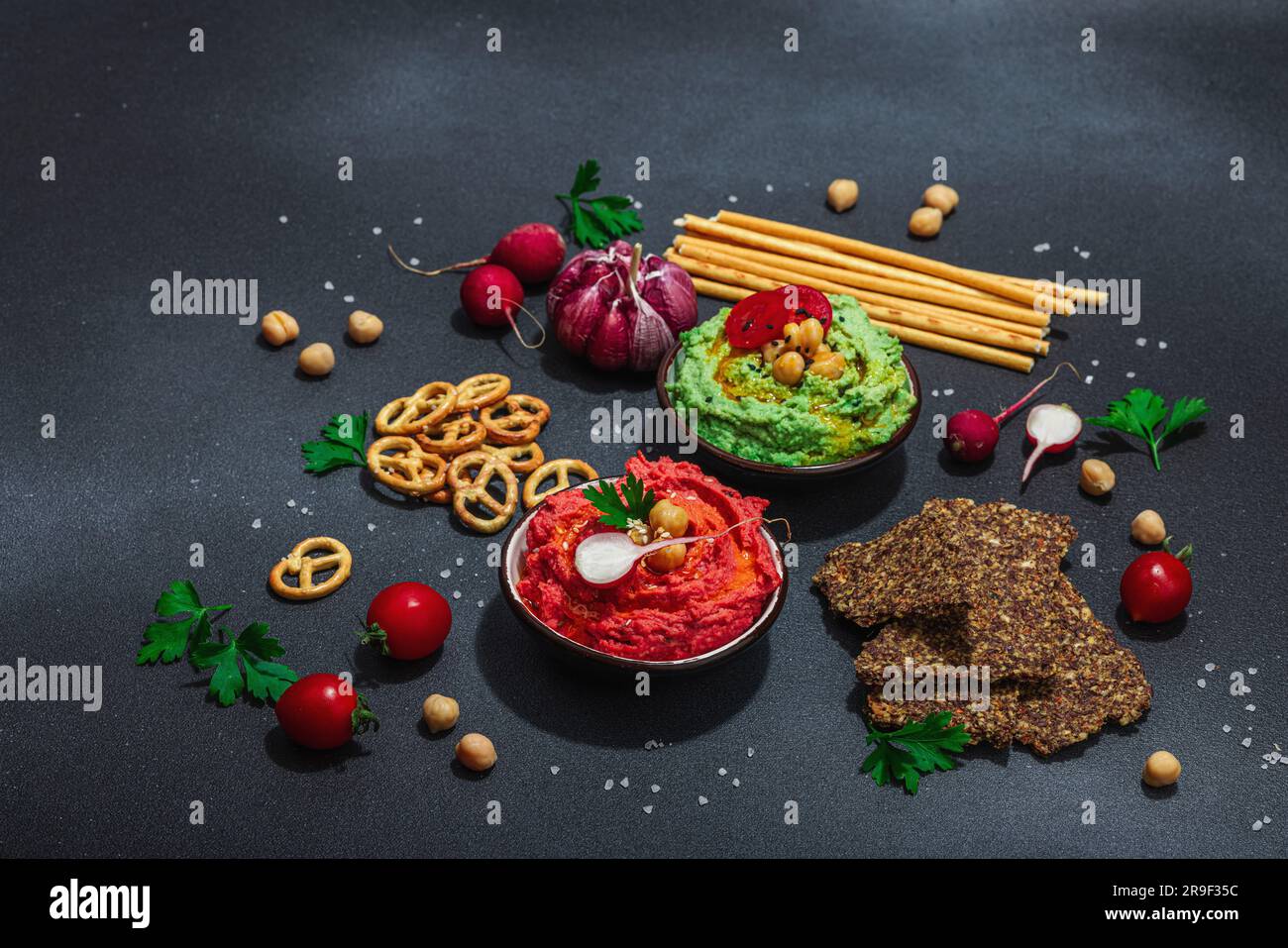 Various hummus dips, fresh vegetables and herbs. Crispy bread snacks ...