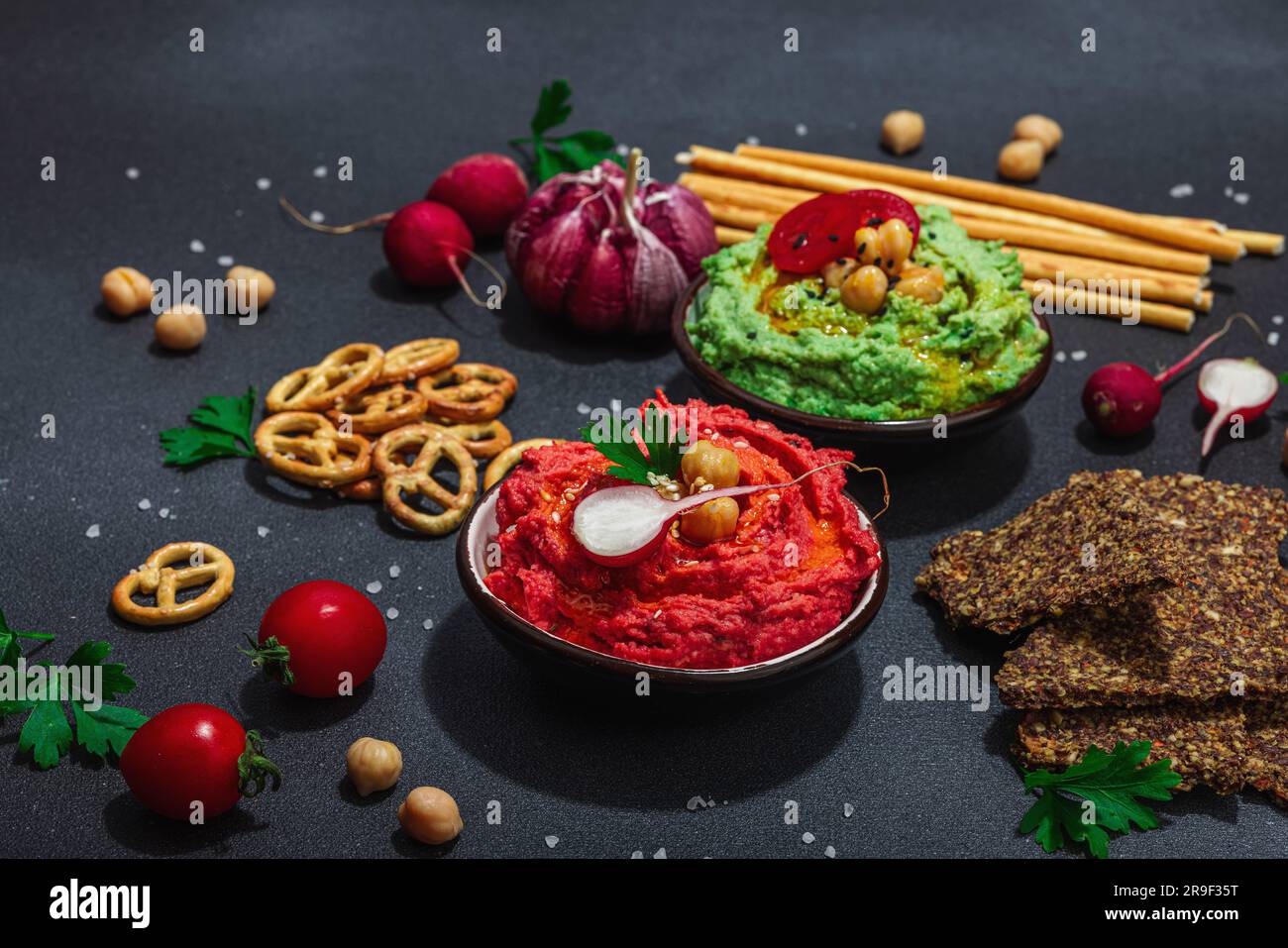 Various hummus dips, fresh vegetables and herbs. Crispy bread snacks ...