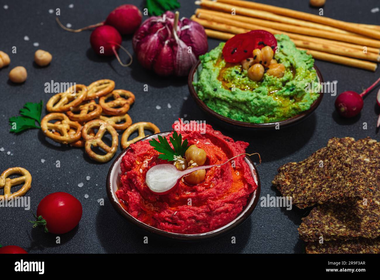 Various hummus dips, fresh vegetables and herbs. Crispy bread snacks ...