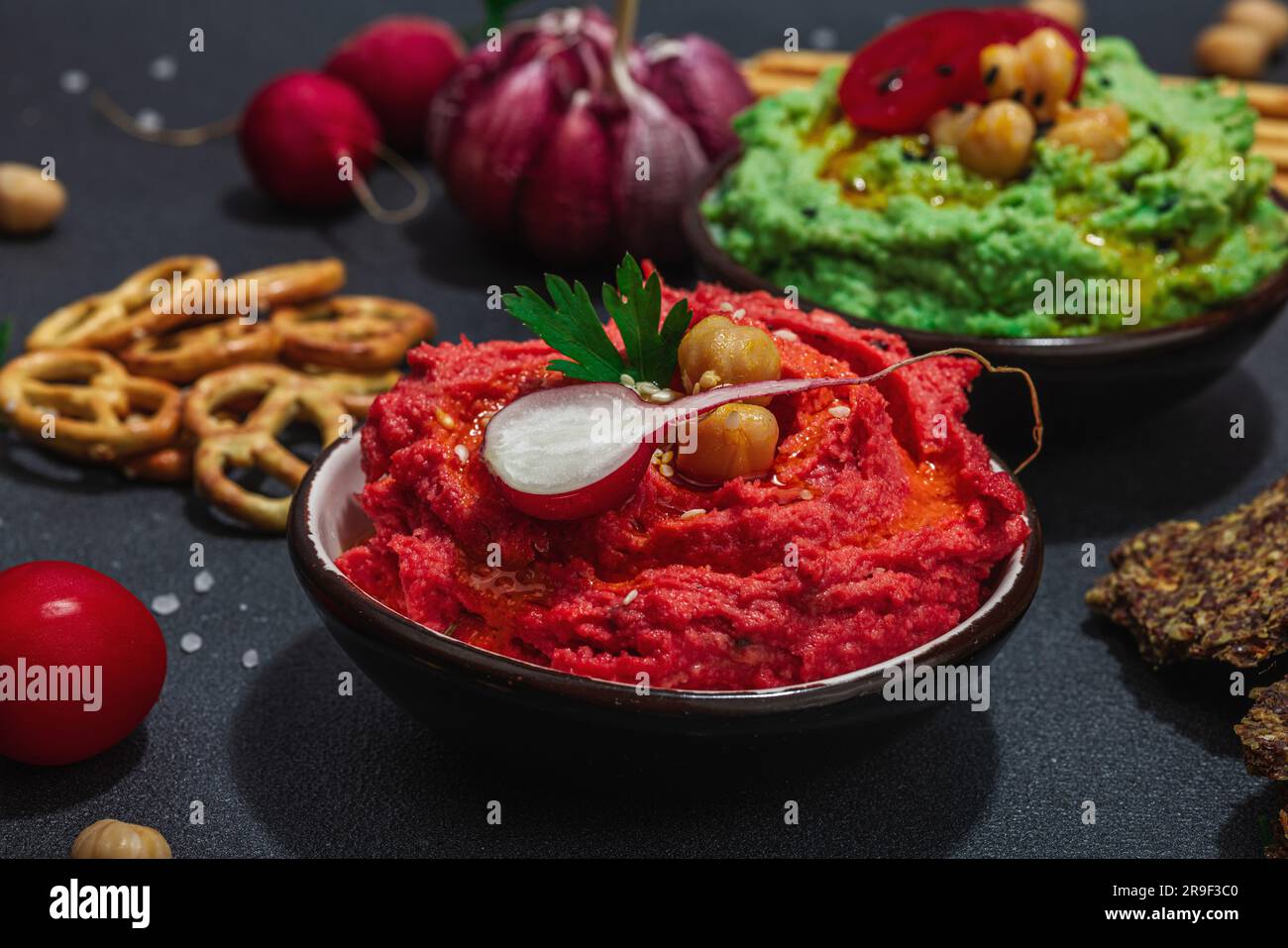 Various hummus dips, fresh vegetables and herbs. Crispy bread snacks ...