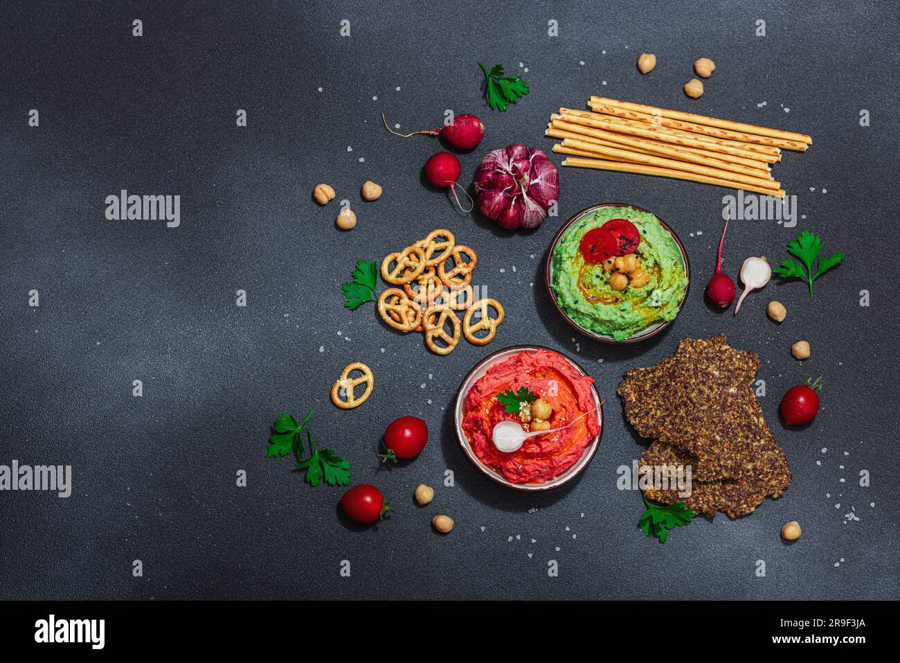 Various hummus dips, fresh vegetables and herbs. Crispy bread snacks ...