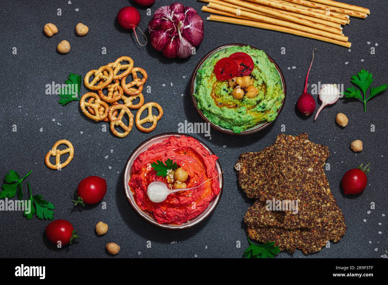 Various hummus dips, fresh vegetables and herbs. Crispy bread snacks ...