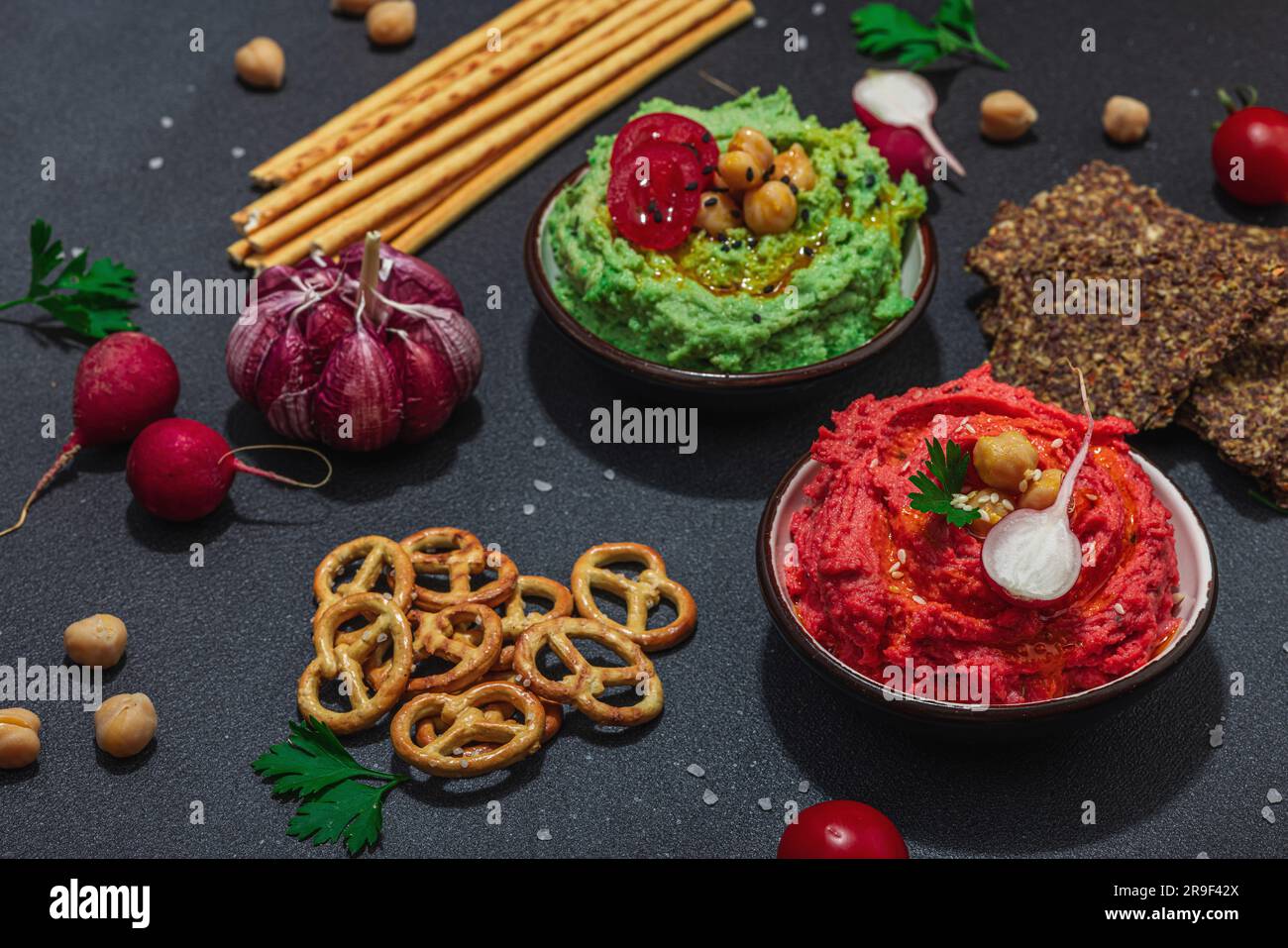 Various hummus dips, fresh vegetables and herbs. Crispy bread snacks ...