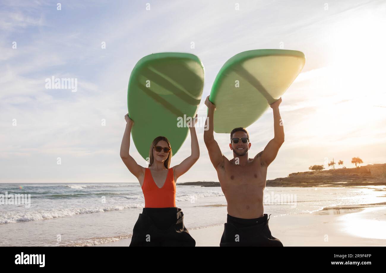 Portrait Of Beautiful Young Couple Surfing Together On The Beach Stock ...