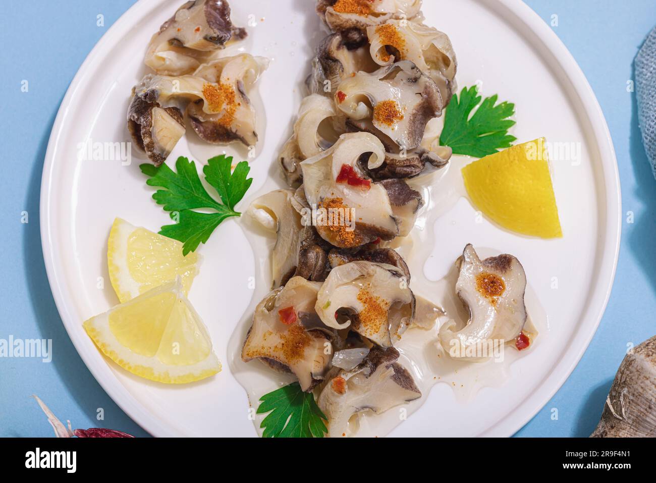 Pickled rapan meat with oil, spices and greens. Healthy seafood rich of ...
