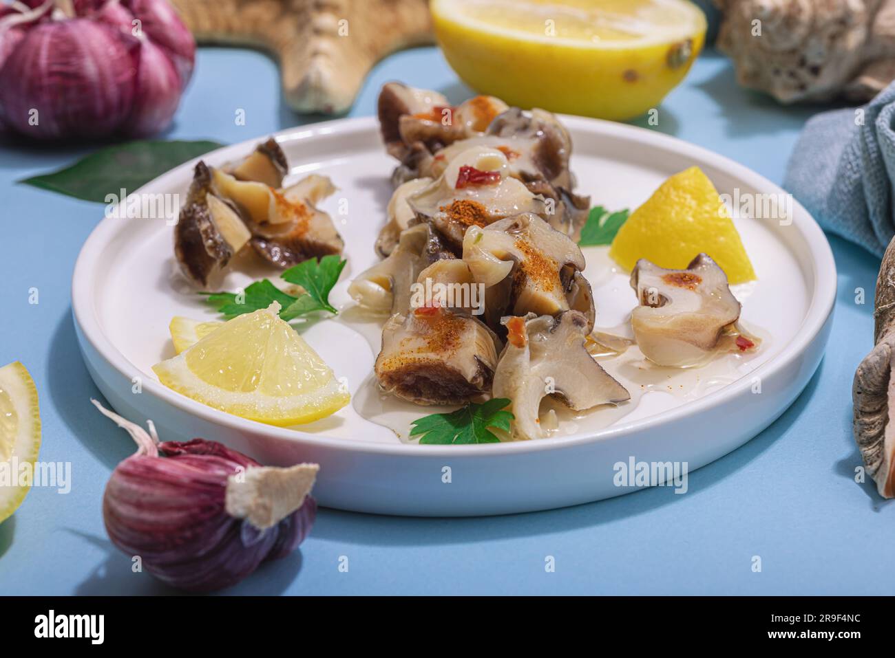 Pickled rapan meat with oil, spices and greens. Healthy seafood rich of ...