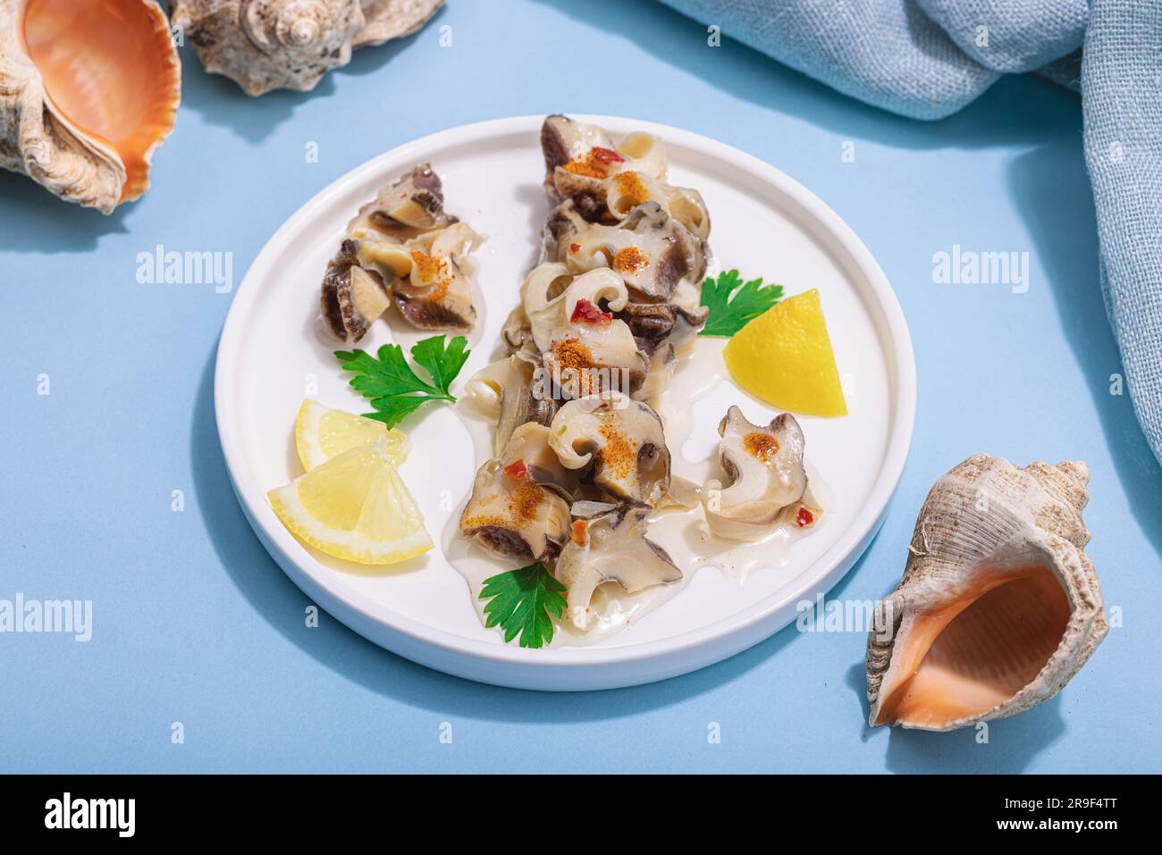 Pickled rapan meat with oil, spices and greens. Healthy seafood rich of ...