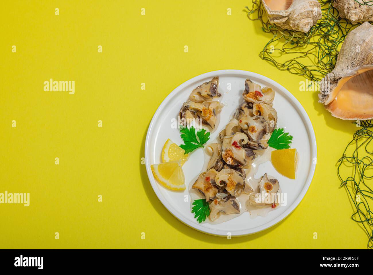 Pickled rapan meat with oil, spices and greens. Healthy seafood rich of ...