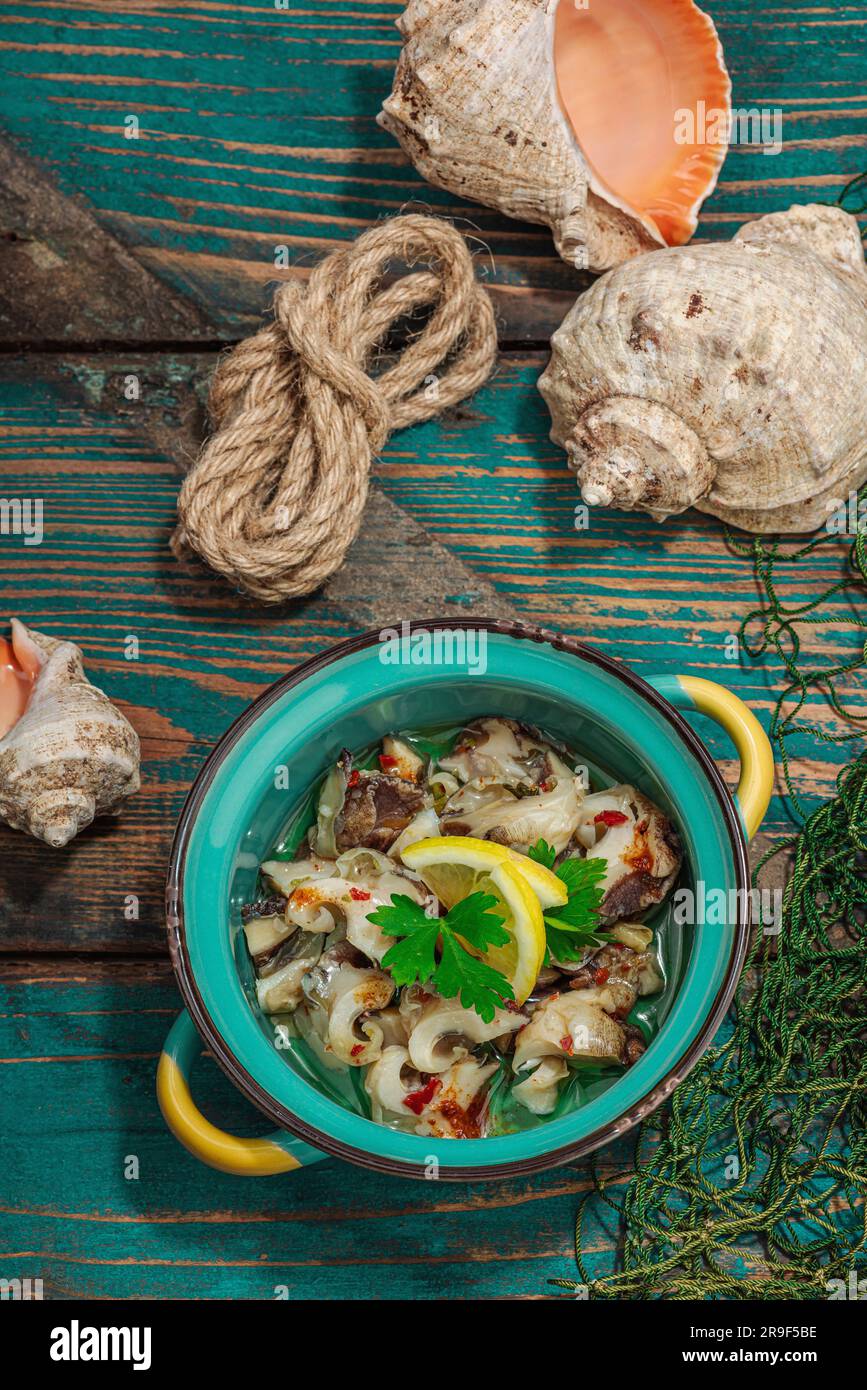 Rapana clam meat with oil, spices and greens. Healthy seafood rich of ...