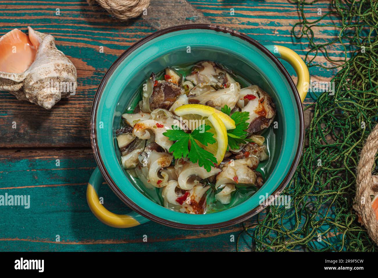 Rapana clam meat with oil, spices and greens. Healthy seafood rich of ...