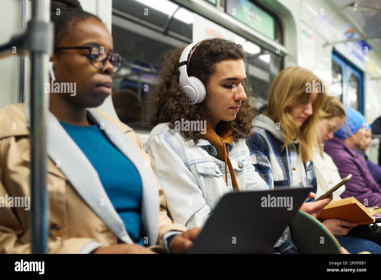 Focus on teenage guy in headphones scrolling through playlist in mobile ...