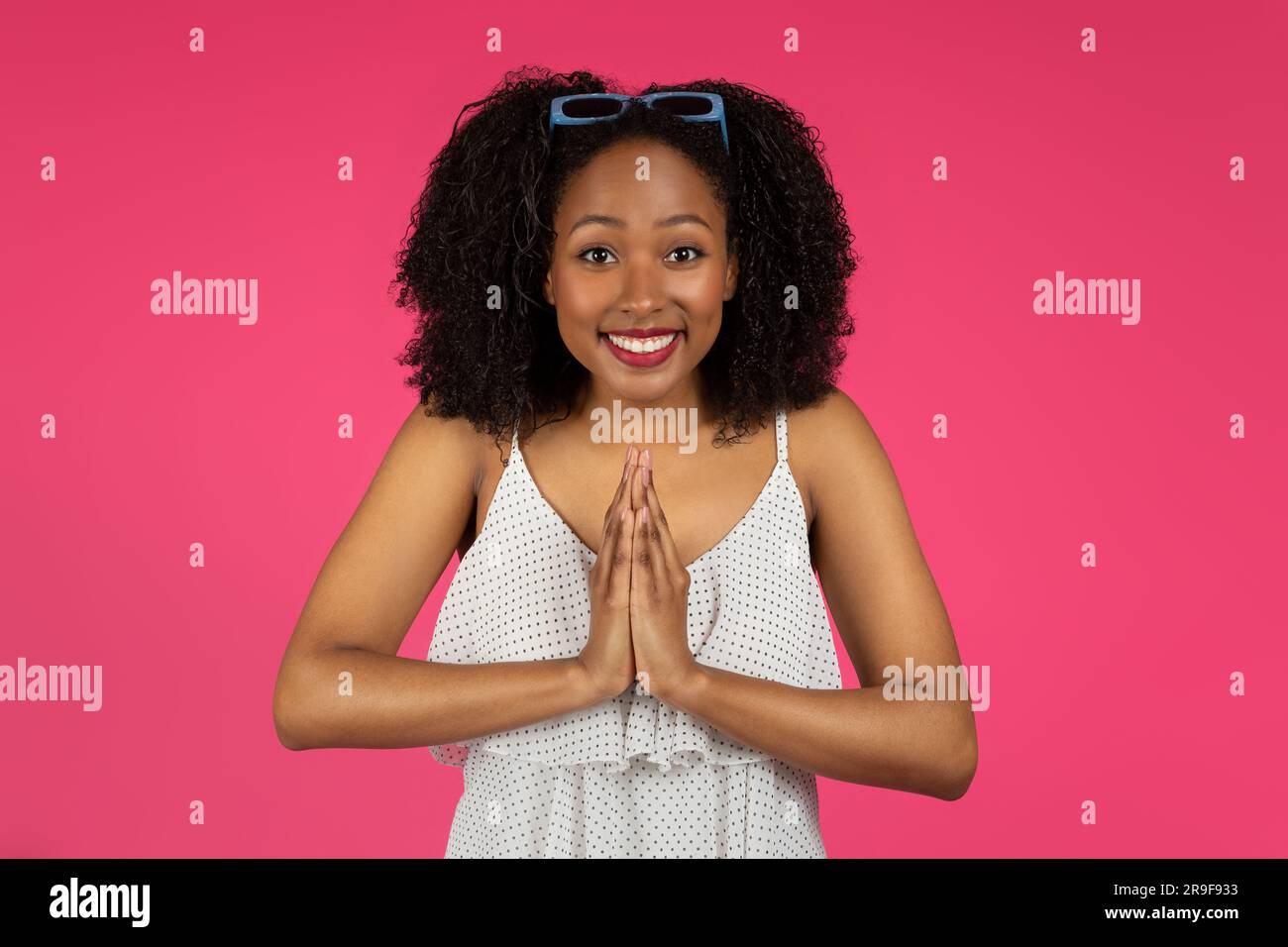 Smiling excited millennial black lady student making prayer gesture ...