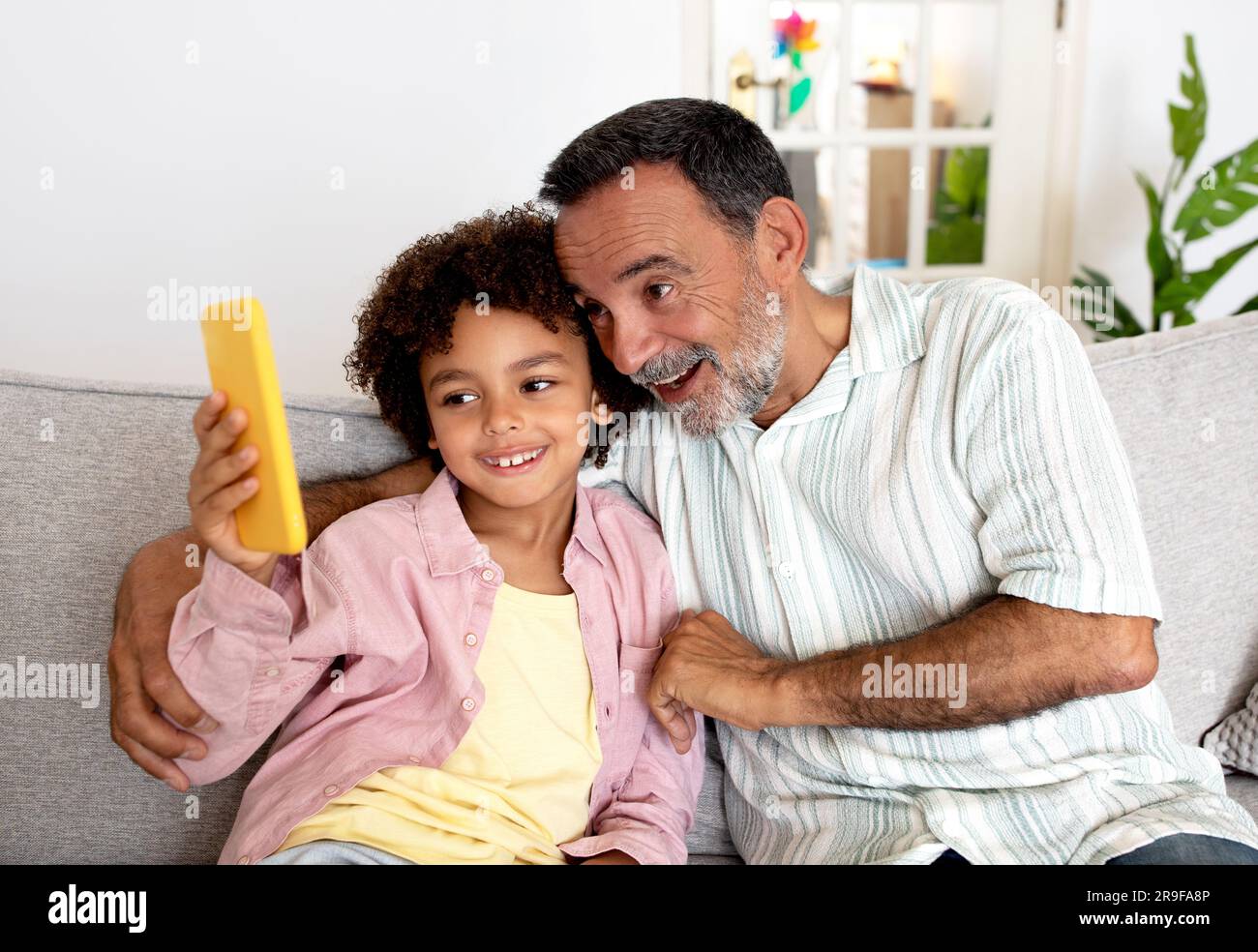 Grandpa grandson using mobile phone hi-res stock photography and images ...