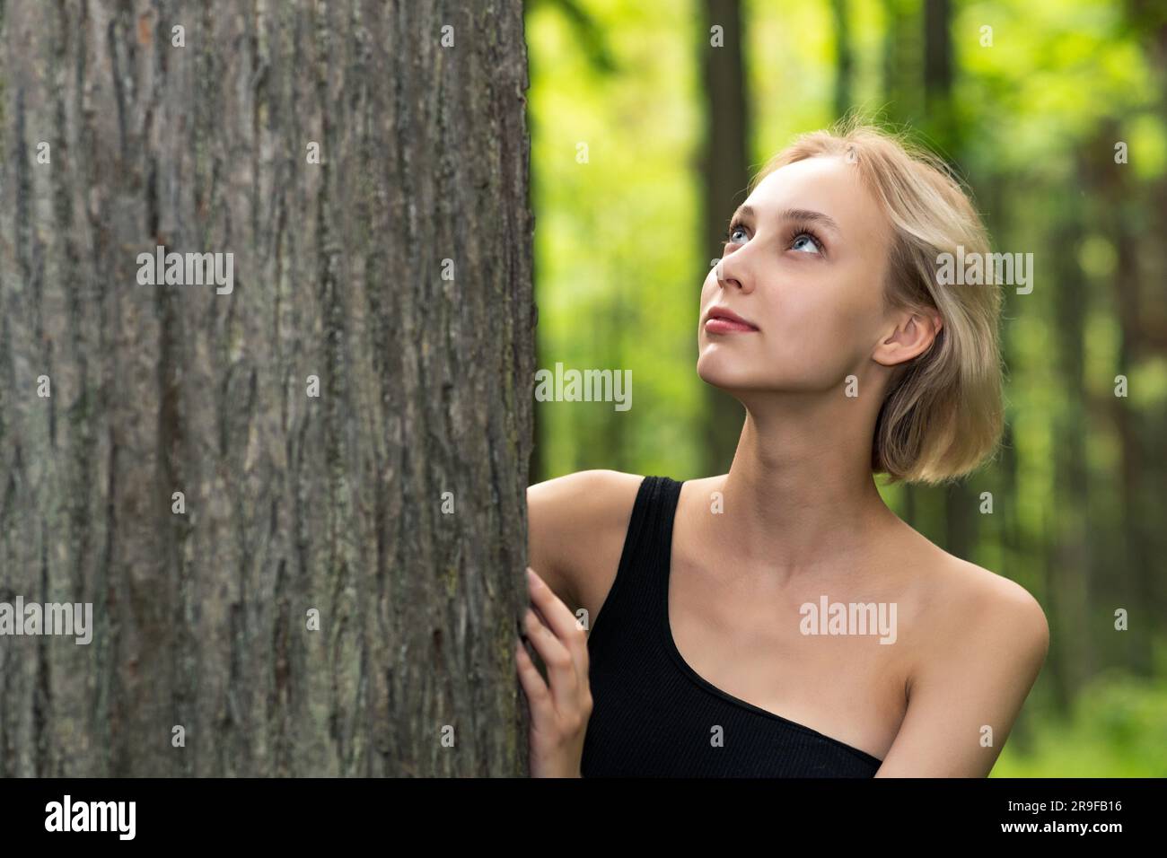 beautiful girl next to the tree in the forest Stock Photo - Alamy