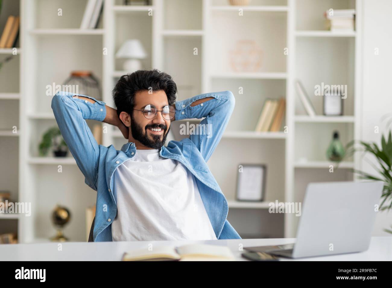 After Productive Day. Happy indian man leaning back in chair and ...