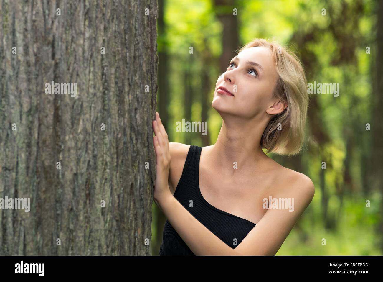 beautiful girl next to the tree in the forest Stock Photo - Alamy